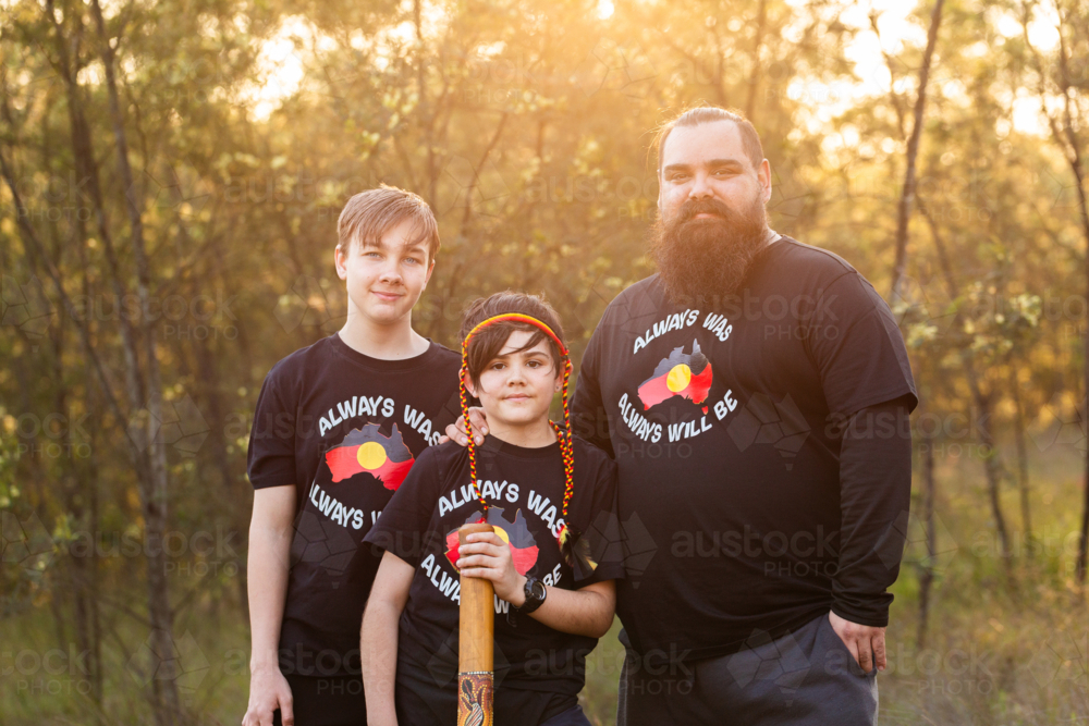 Image of Aboriginal dad standing together with boys in golden light in ...