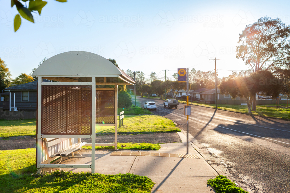 Image of Empty suburban roadside bus stop in golden afternoon light ...