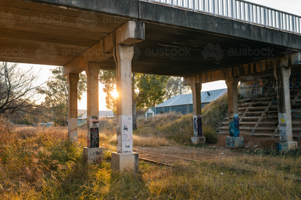 Image of Old rail crossing bridge in small town with graffiti on poles ...