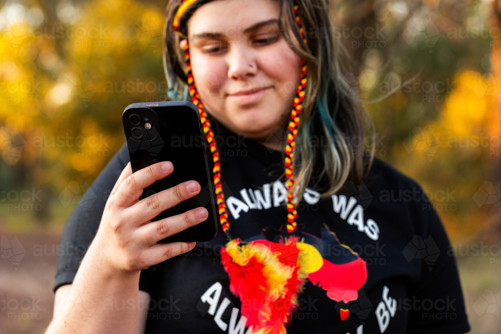 Image of Portrait of Aboriginal Australian teenaged girl using mobile ...