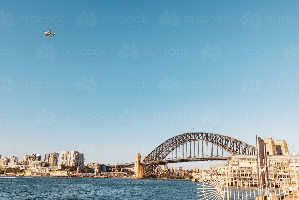 Image of Seaplane flying over the Sydney Harbour Bridge on bright day ...